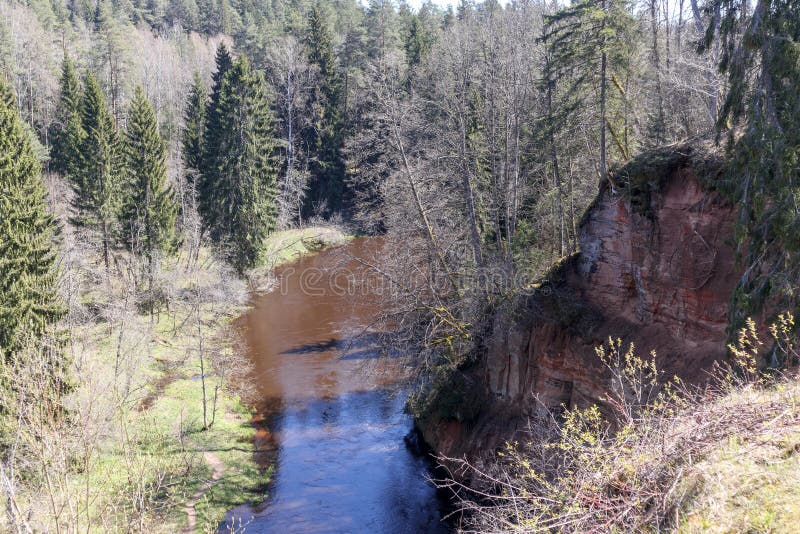.a River that Flows Along Reddish-brown Sandstone Cliffs Overgrown with ...