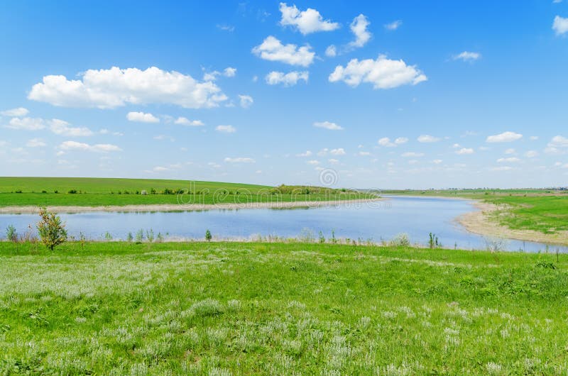 A River in Green Grass Under a Blue Sky with Clouds Stock Photo - Image ...