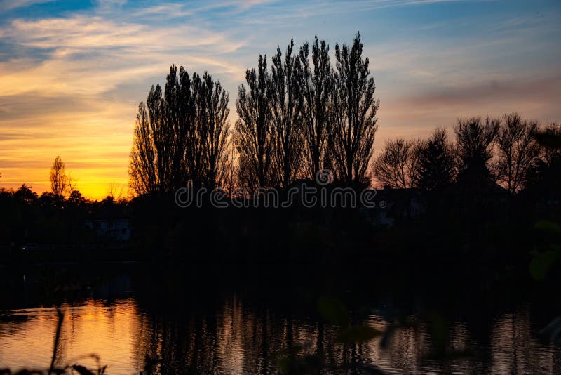 River Reflecting a Dark Forest during Sunset Stock Photo - Image of ...