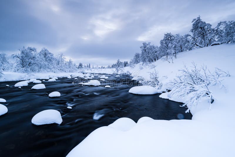 River with Snow in it and a Forest Near Covered with Snow in Winter in ...