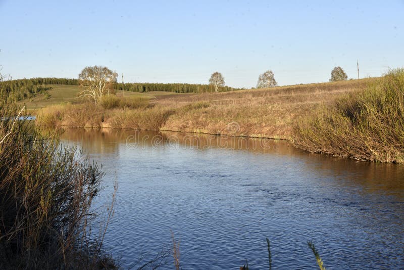 River in Spring among Reeds and Mountainous Terrain Stock Image - Image ...