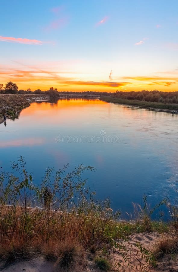 River at Sunset Time with a Yellow Sun and Clouds Stock Image - Image ...