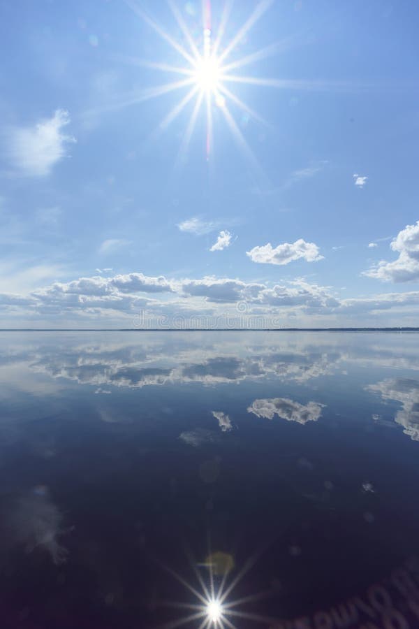 River View with Clouds Reflected in it, the Sun in the Frame and the ...
