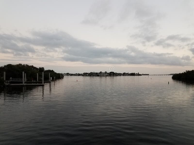 River Water with Dock and House and Clouds Stock Image - Image of ...