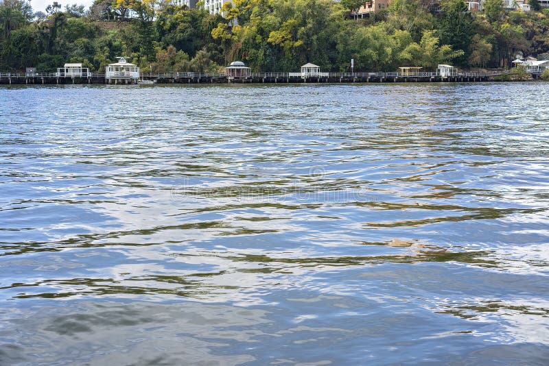 River Water Foreground with Buildings and Boardwalk Background Stock ...