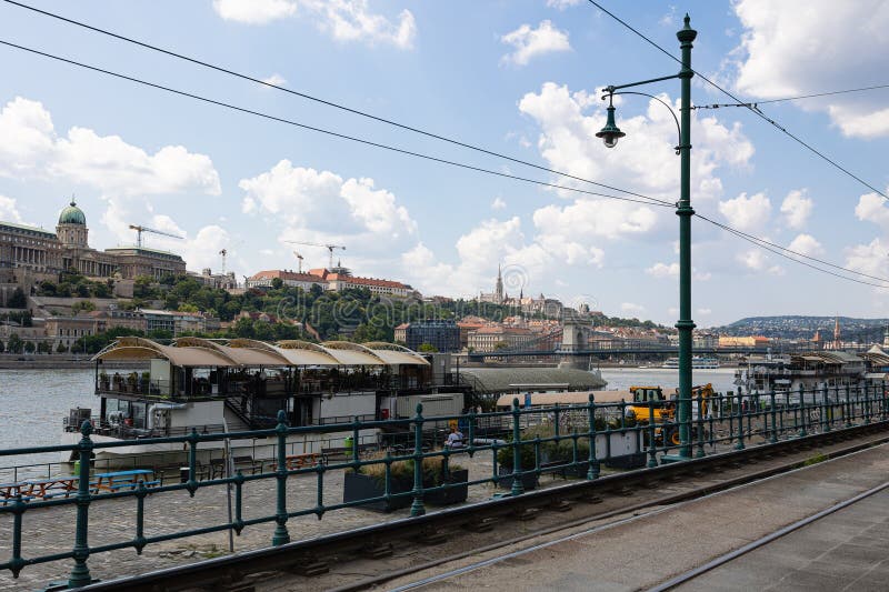 A Riverfront View of Budapest: Cityscape with Boats and Bridge Stock ...