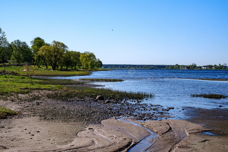 Riverside Shore in Spring with Scenic Trees and Green Pastures Stock ...
