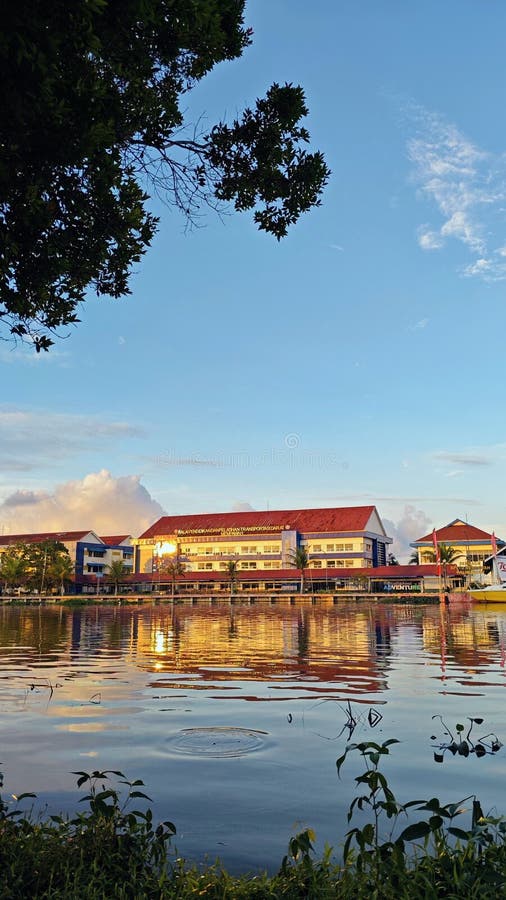 A Riverside Structure at Sunset with Warm Light and Gentle Reflections ...