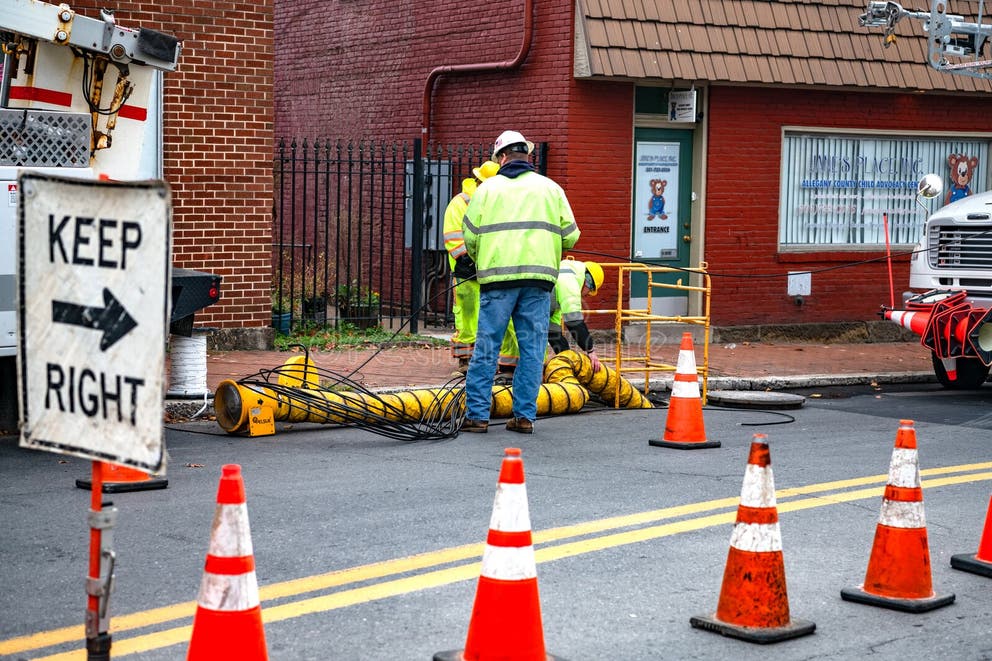 Road Closure. Verizon Workmen Lowering Cable into a Manhole Editorial ...