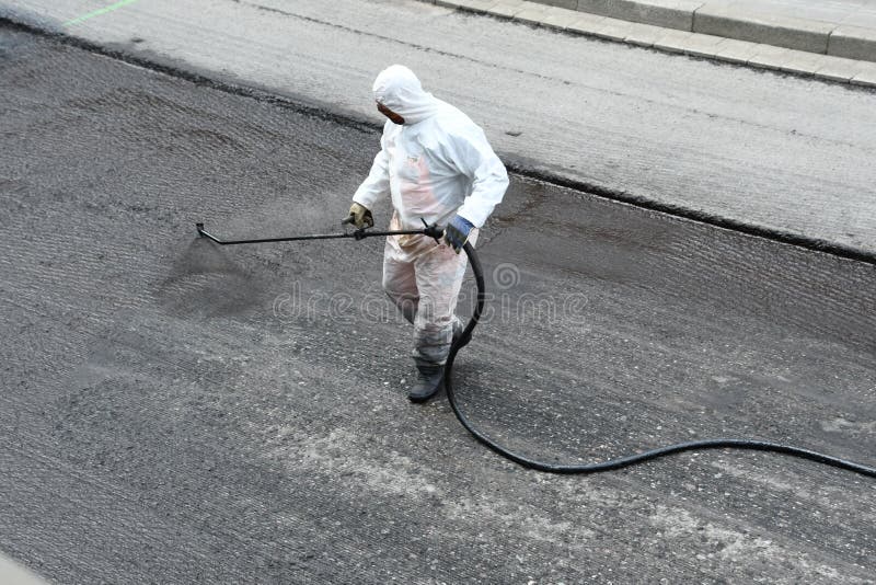 Road Construction Worker Working Spraying Liquid Bitumen on Road ...