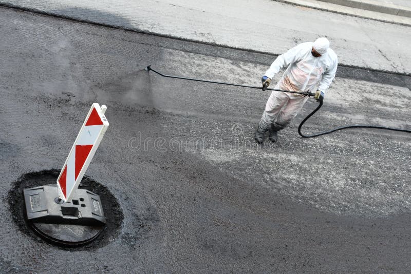 Road Construction Worker Working Spraying Liquid Bitumen on Road ...