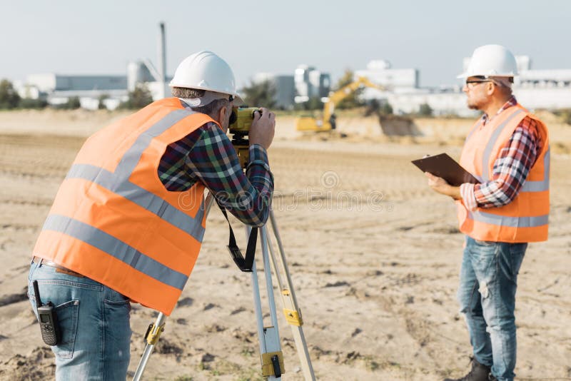 Road Construction Workers Using Measuring Device on the Field Stock ...