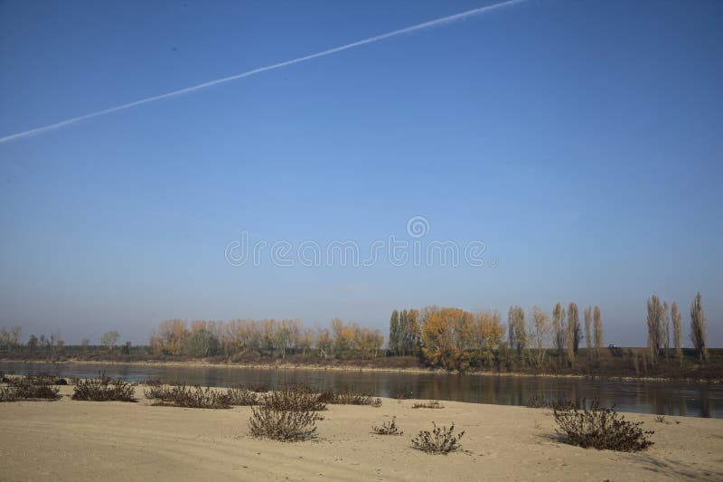 Road with Cypresses on an Embankment by a River with Its Reflection on ...