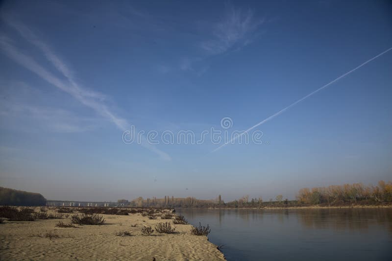 Road with Cypresses on an Embankment by a River with Its Reflection on ...