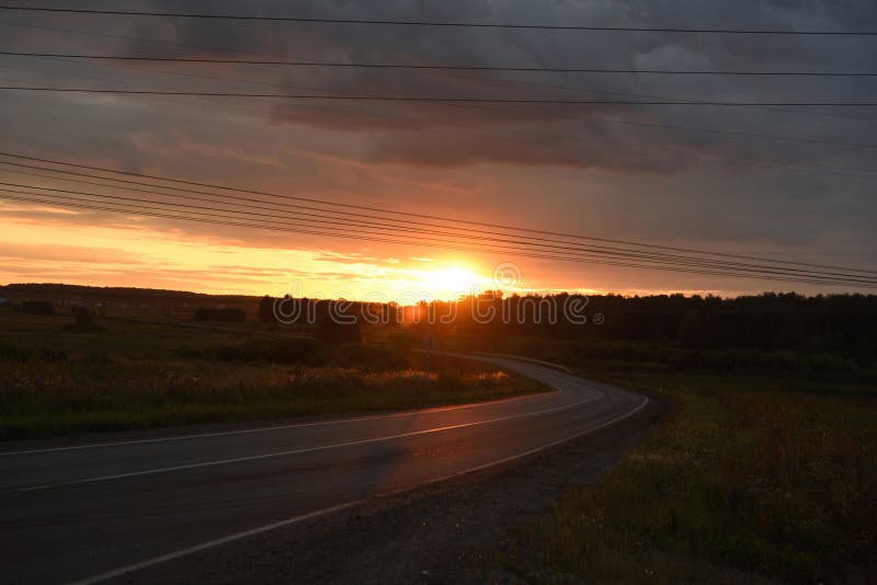 The Road Going into the Sunset. Evening Sun on the Horizon and a Rural ...