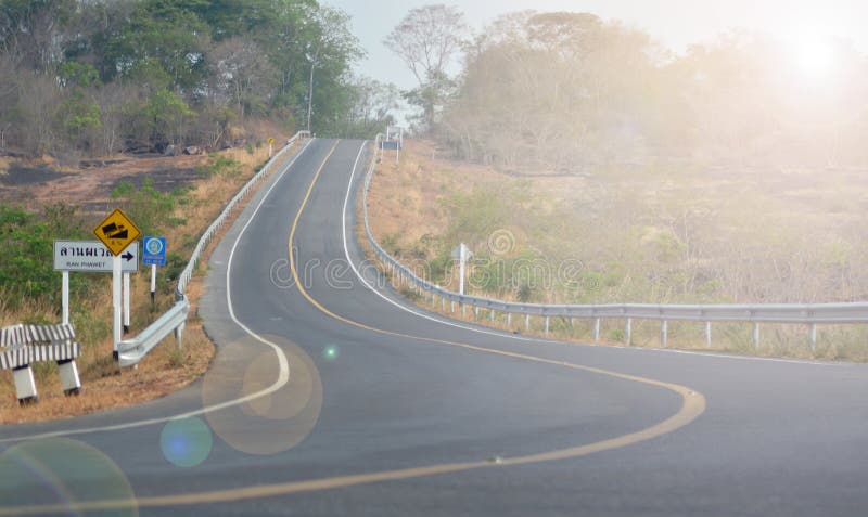 The Road Has a Yellow Line and There is a Warning Sign on the Steep ...