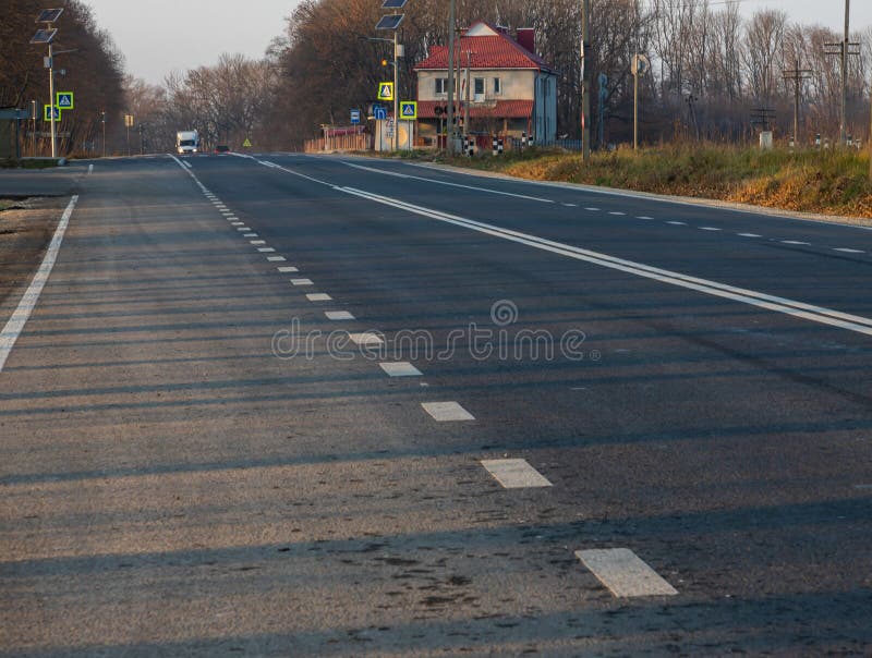 Road Lined with Autumn Trees. Cross Hatching Road Marks Line the Centre ...