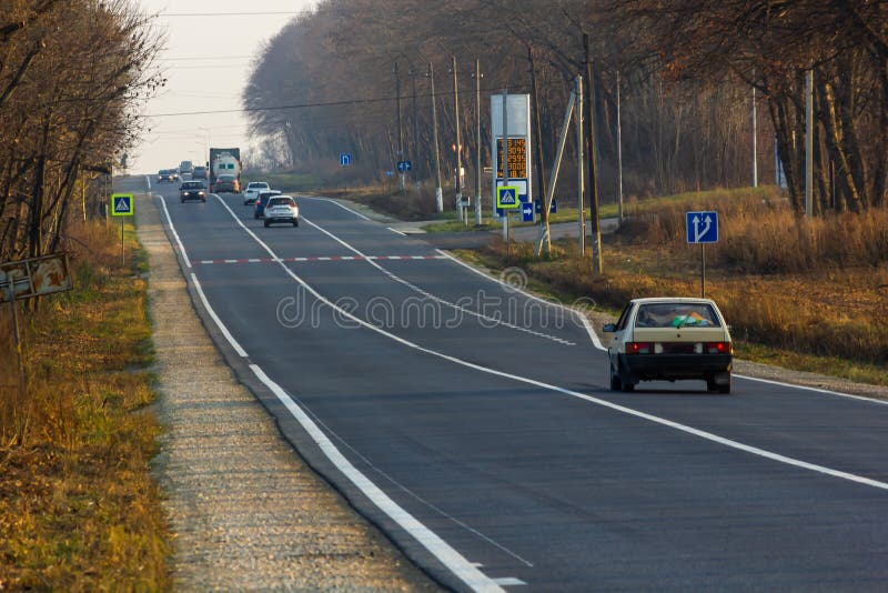 Road Lined with Autumn Trees. Cross Hatching Road Marks Line the Centre ...