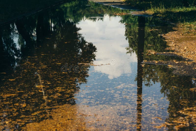 Road after a Rain. Reflection of Clouds in a Puddle after a Rain Stock ...