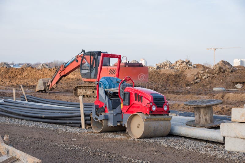 Road Roller and Excavator Working at Construction Site during Asphalt ...