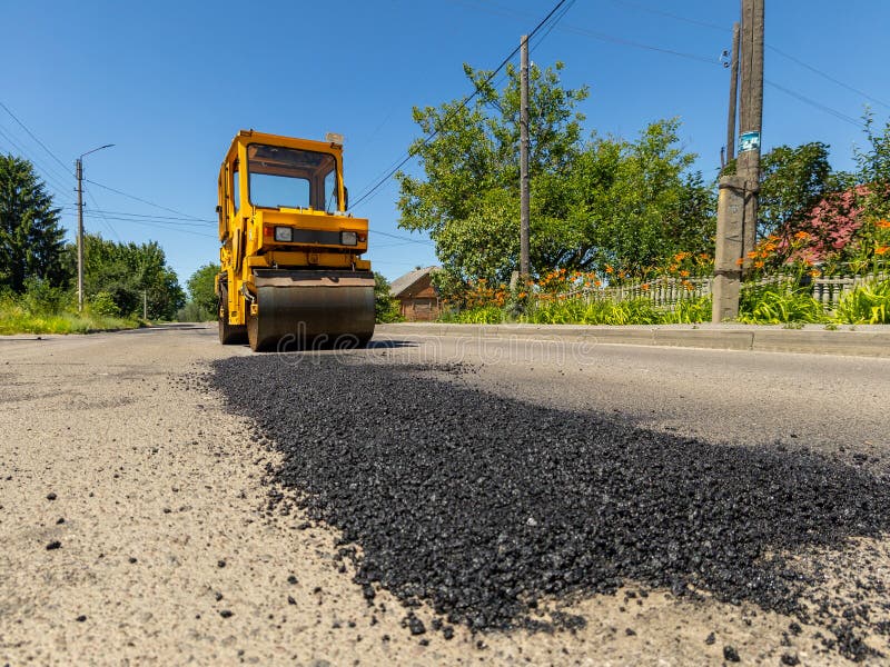 A Road Roller is Laying Asphalt on the Side of the Road Stock Image ...