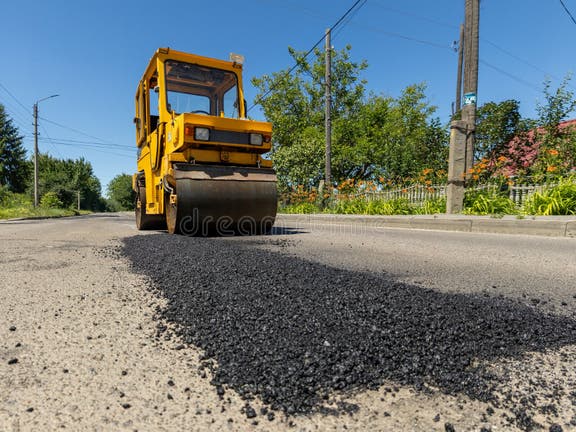 A Road Roller is Laying Asphalt on the Side of the Road Stock Photo ...