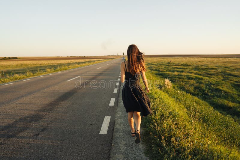 A Young Girl is Walking Along the Road. Stock Photo - Image of road ...