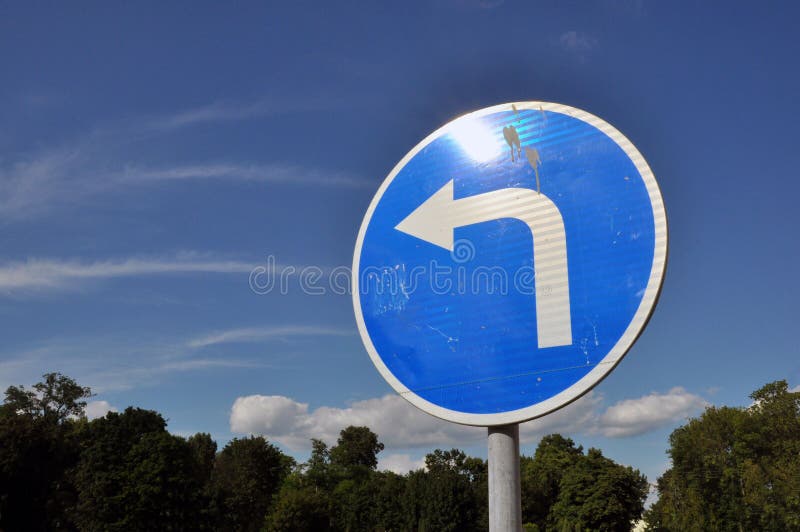 Road Sign Showing Left Turn Against Blue Sky Stock Image - Image of ...