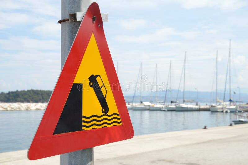 Road Sign Indicating a Risk of Falling into the Water with a Car Stock ...