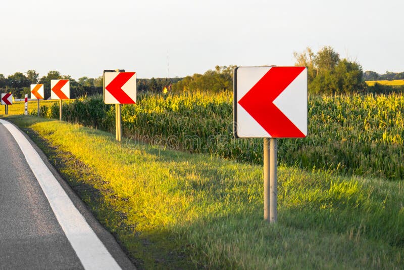 Road Signs in European Style Warn of a Sharp Turn on a Narrow Road, a ...