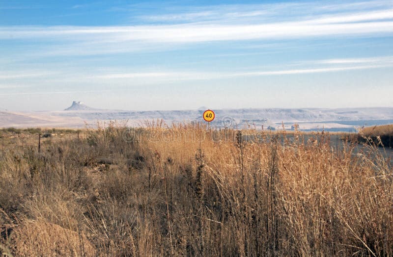 Road with Speed Limit Sign Winding through Dry Winter Landscape Stock ...