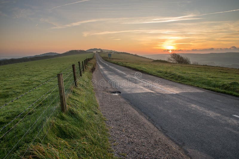 Road at Sunrise Over Hills in Dorset Stock Photo - Image of mist, hedge ...