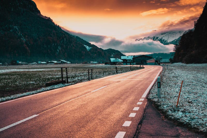 Road at Sunset Leading To Snow Covered Mountain Peaks Stock Image ...