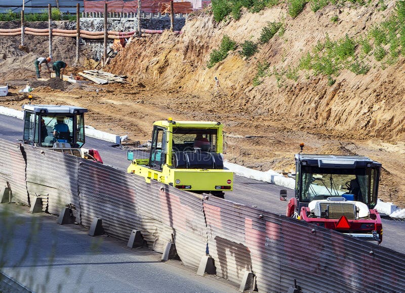 Road Work at a Construction Site. Three Rollers Move One after Another ...