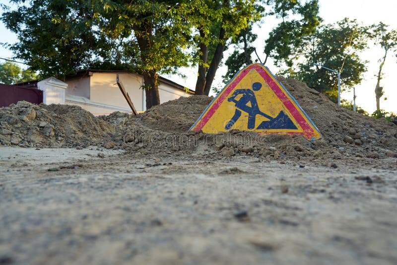Road Work Sign Placed on a Pile of Dug Up Land in the Middle of a Road ...