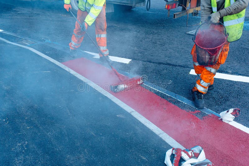Road Workers Applying Hot Red Road Marking Paint on New Build Road ...