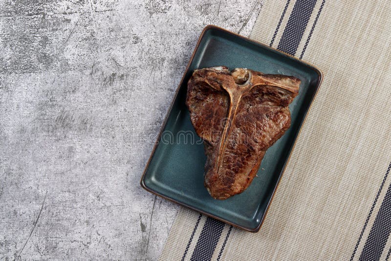 Roast T-bone Steak on a Rectangular Plate on a Dark Background Stock ...
