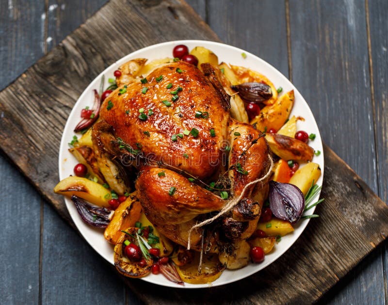 Roast Whole Chicken with Roast Vegetables on Plate on a Table Stock ...