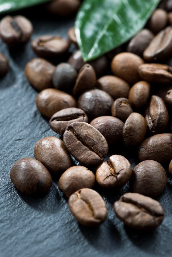 Roasted Coffee Beans and Leaves on a Dark Background, Vertical Stock ...