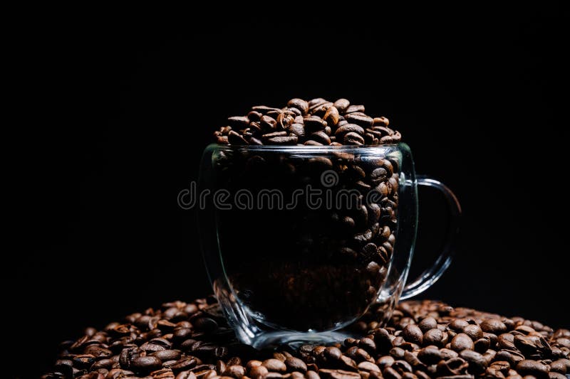 Roasted Coffee Beans Overflowing a Glass Cup on a Black Background ...
