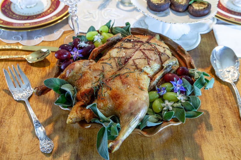 Roasted Duck on a Platter with Sage Leaves and Grapes Stock Photo ...