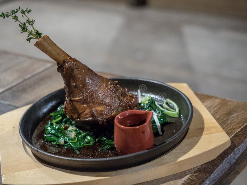 Roasted Lamb Knuckle Served with Fried Spinach and Thymus on Rustic ...