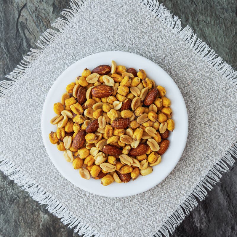 Roasted Peanuts, Corn and Almonds on a Plate on a Napkin Stock Photo ...