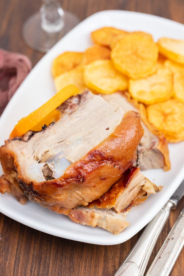 Roasted Piglet with Potato Chips and Orange Stock Photo - Image of ...