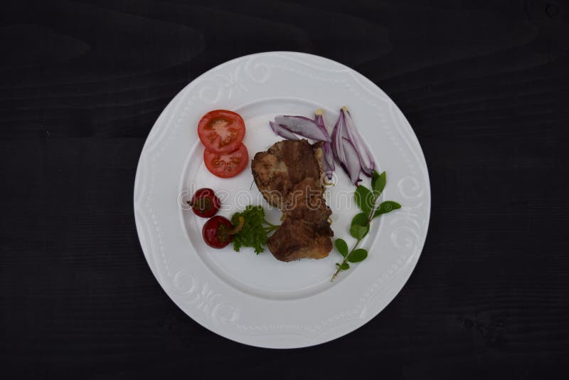 Roasted Pork Meat on a White Plate and Black Cutting Board. Stock Photo ...