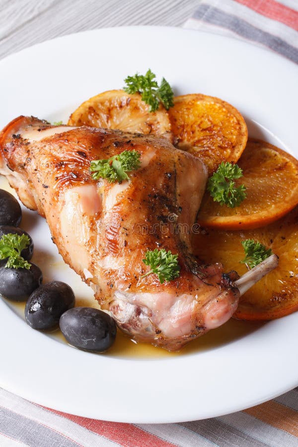 Roasted Rabbit Leg with Oranges and Olives on the Plate. Vertical Stock ...