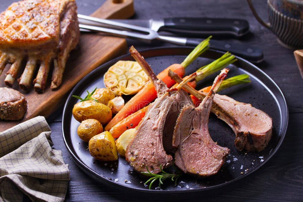 Roasted Rack of Lamb. Lamb Chops with Vegetables on Black Plate. Stock ...