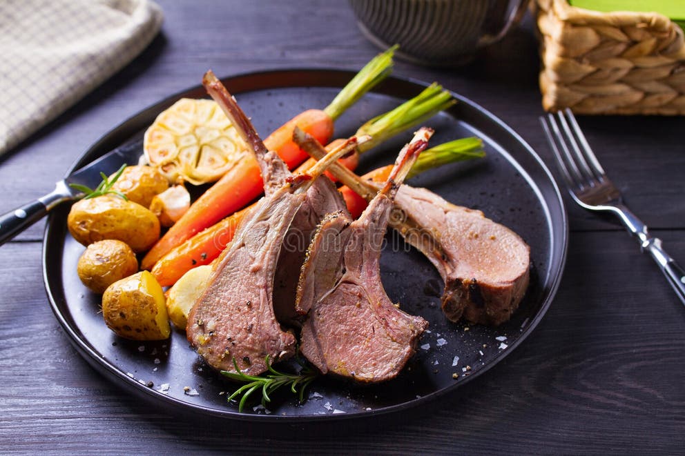 Roasted Rack of Lamb. Lamb Chops with Vegetables on Black Plate. Stock ...
