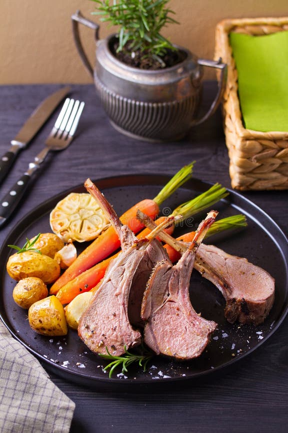 Roasted Rack of Lamb. Lamb Chops with Vegetables on Black Plate. Stock ...
