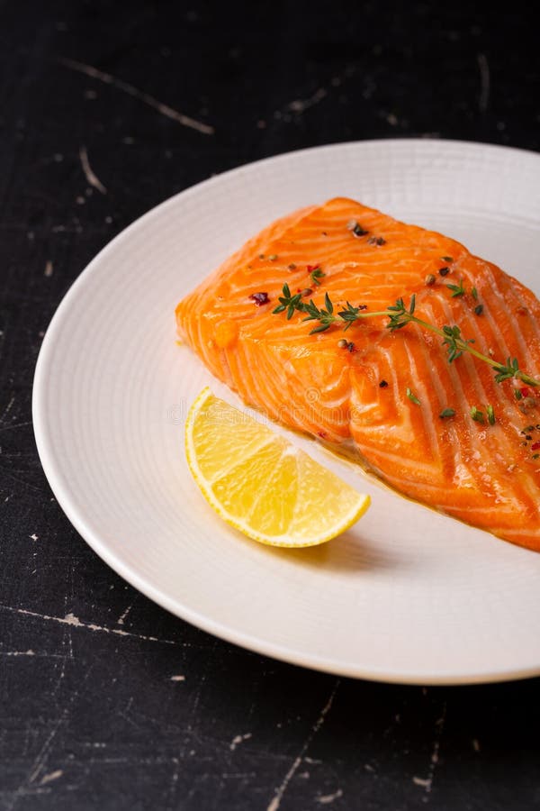 Roasted Red Fish on White Plate on Dark Surface Stock Image - Image of ...